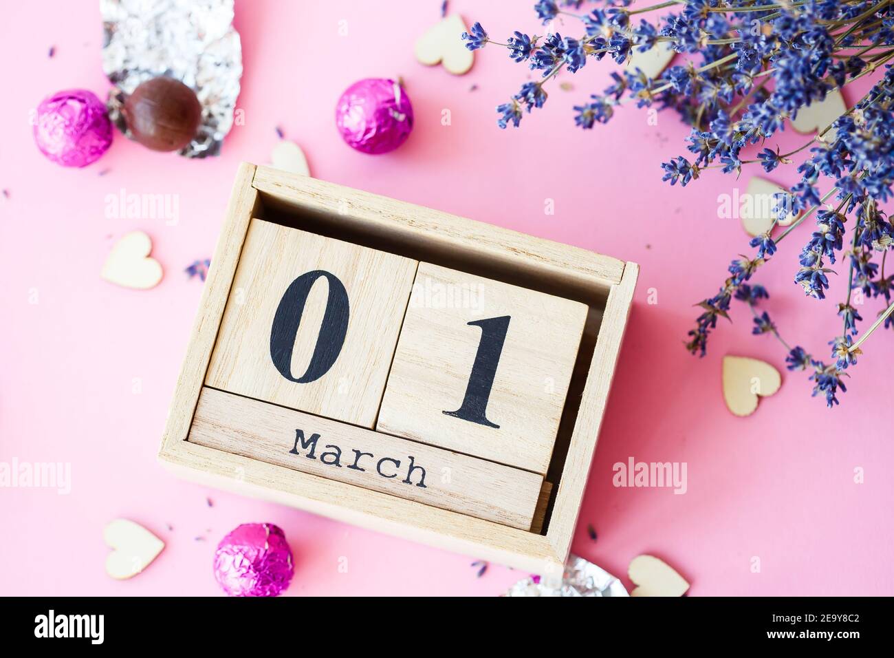 Wooden calendar with the date of March 1 on a pink background, a place ...