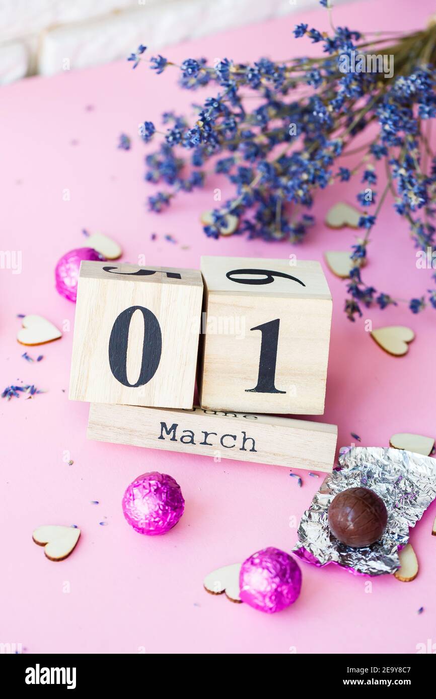 Wooden calendar with the date of March 1 on a pink background, a place ...