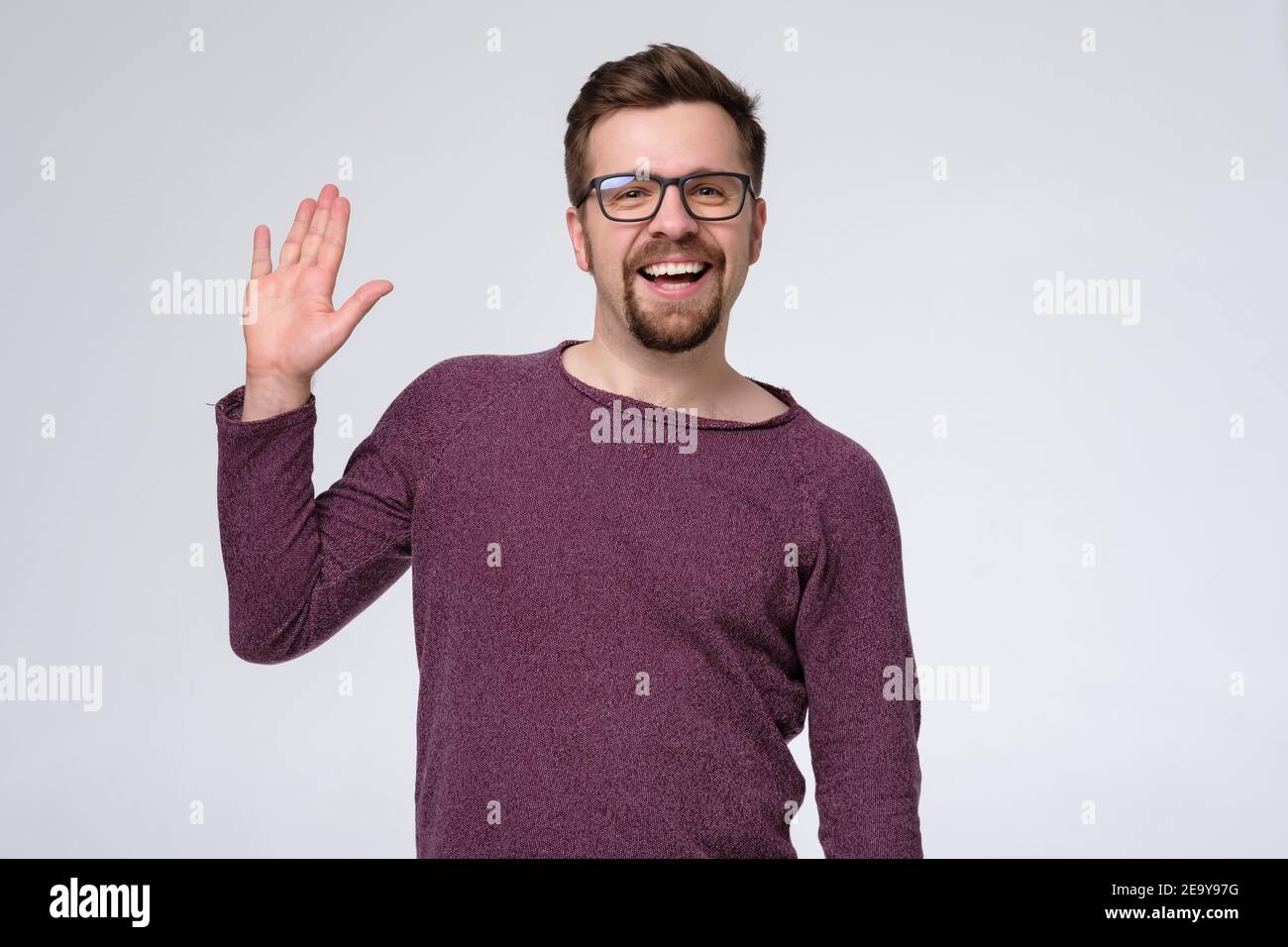 Mature caucasian man saying hello, waving a hand. Welcome home sign ...