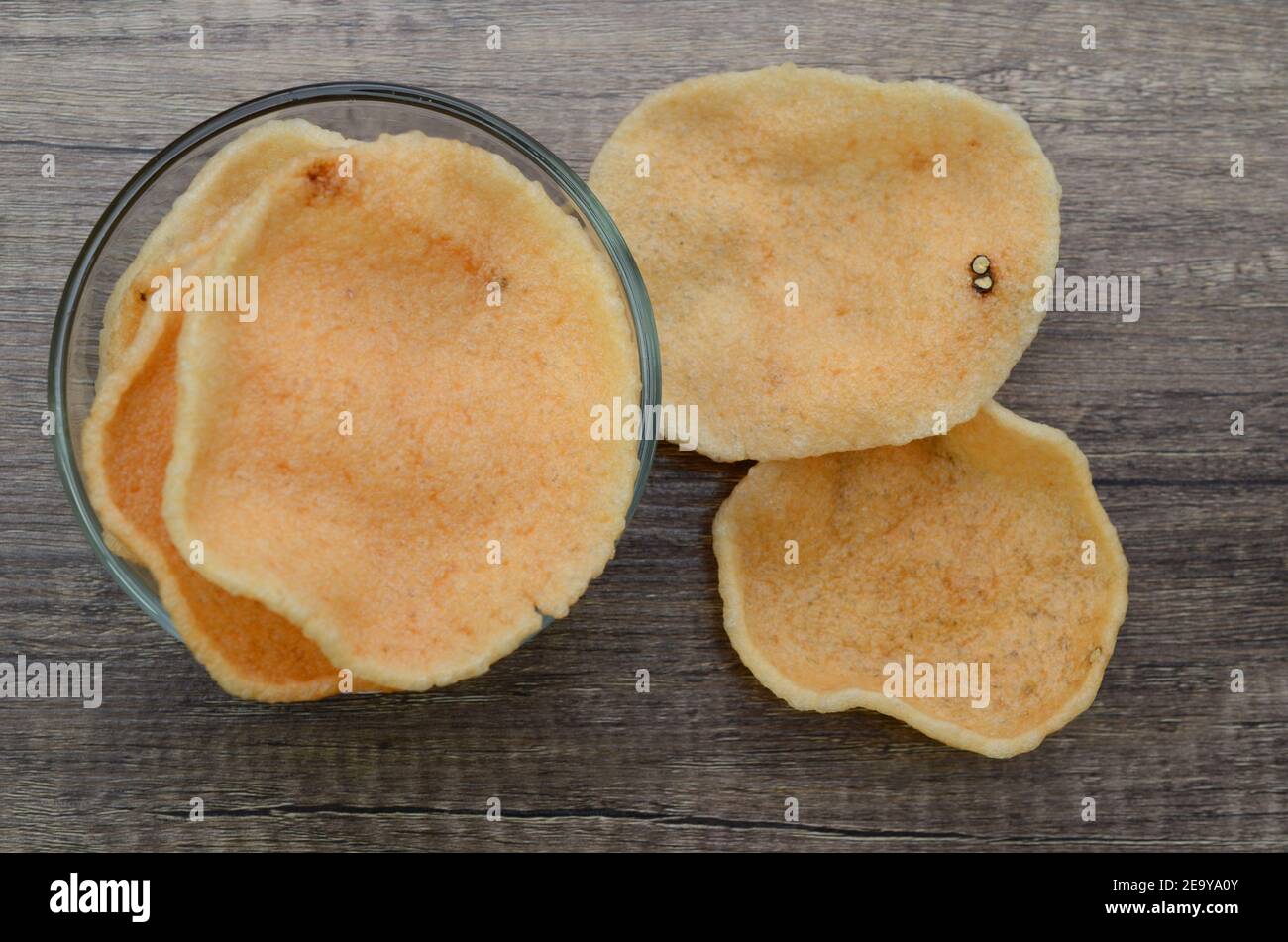 Prawn crackers in a glass bowl isolated on wooden background Stock ...