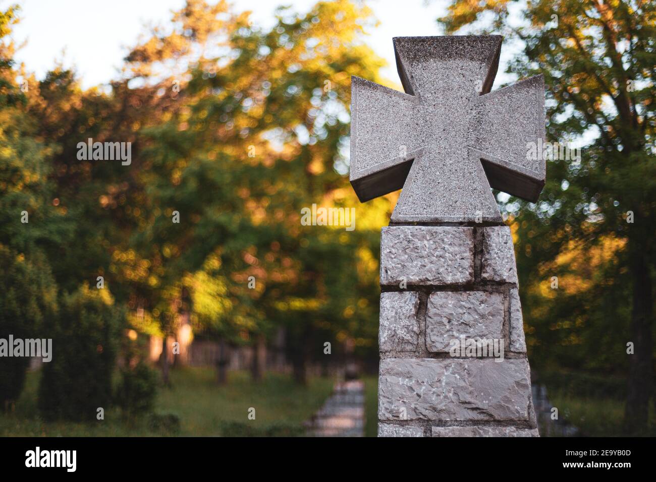 Equilateral stone cross on a pedestal with a beautiful colored ...