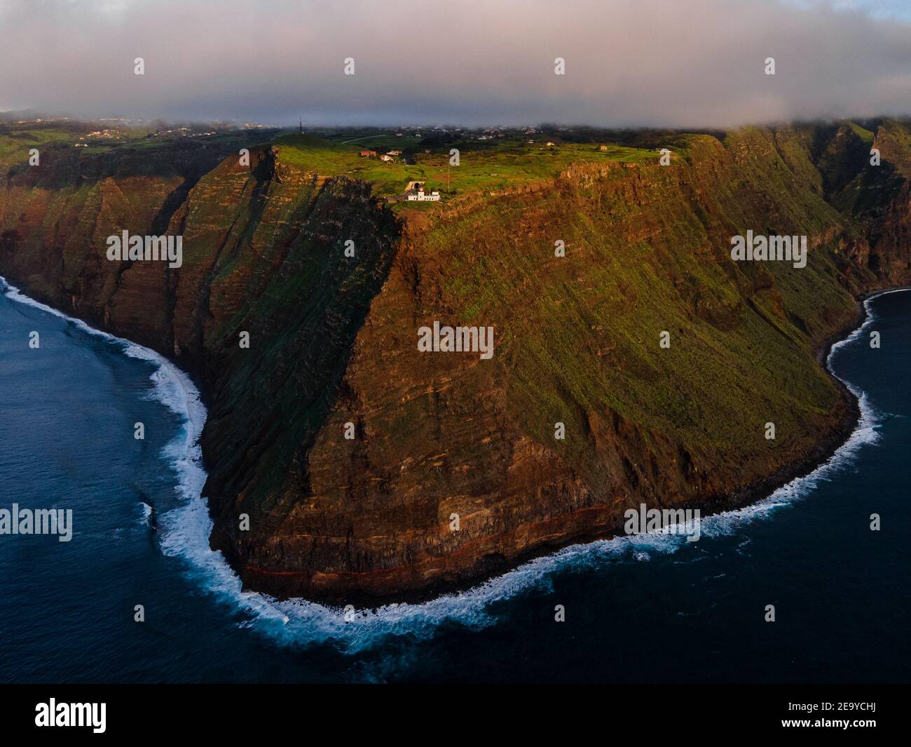 The cliff lighthouse Ponta do Pargo on the cliff coast of the Island of ...