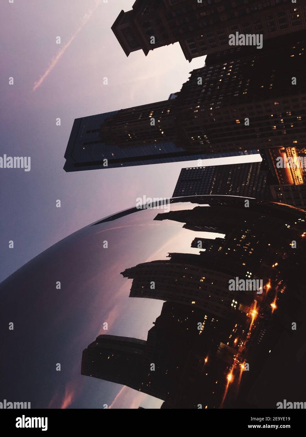 Vertical shot of illuminated high-rise buildings with a mirror ...