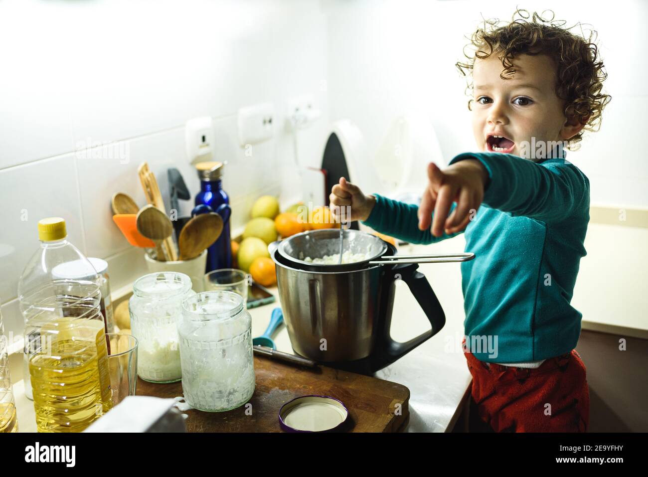 Adorable little girl helps to cook and makes funny and curious ...