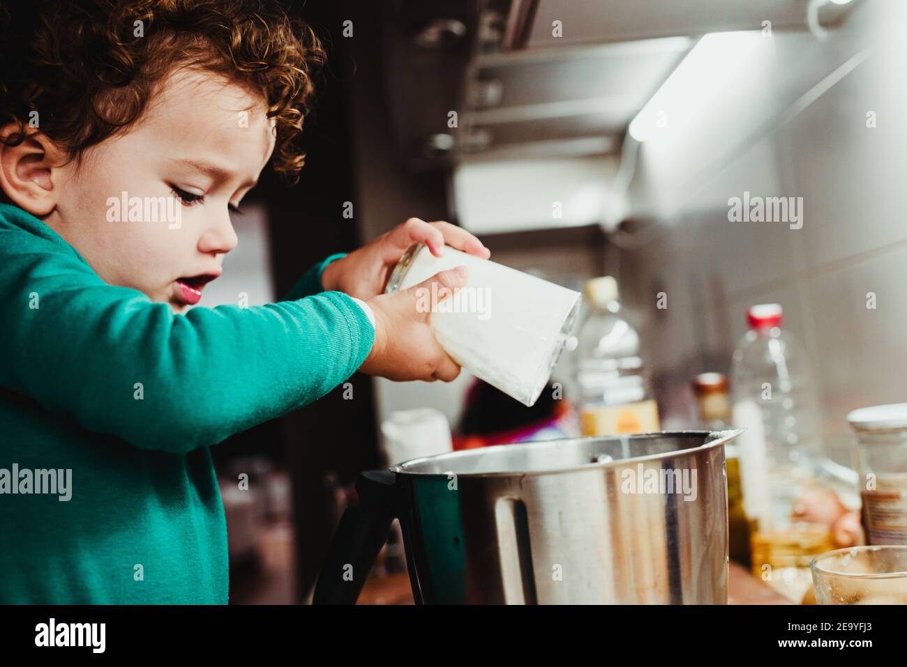 Adorable little girl helps to cook and makes funny and curious ...