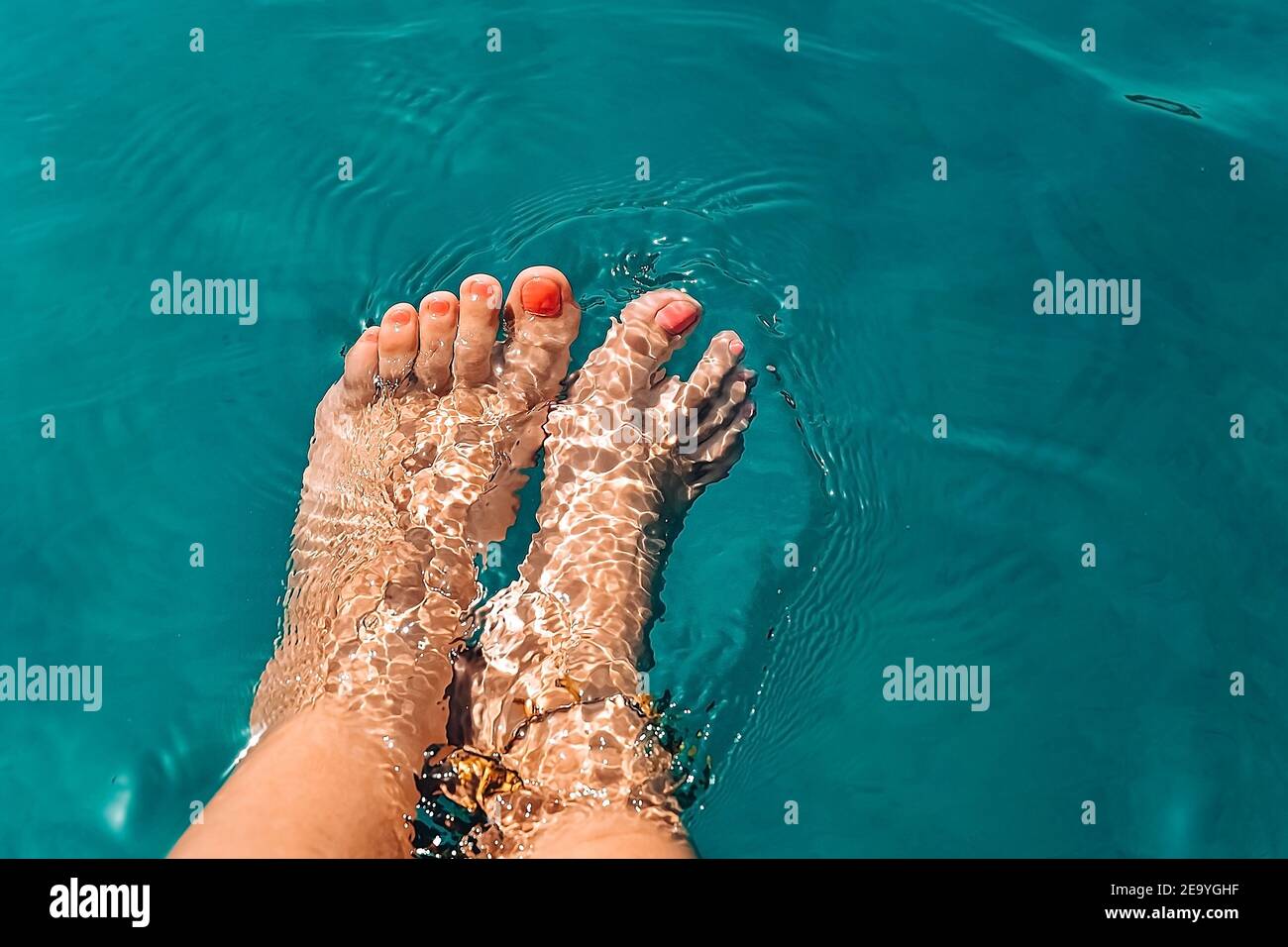 female feet in the water, beautiful bright blue water, texture of the ...