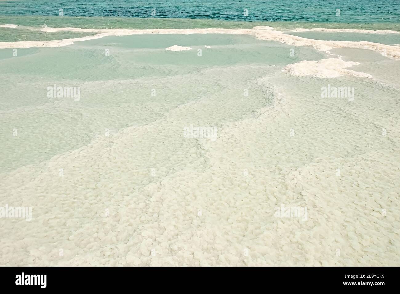 Texture of salt deposits in water.on the beach in the blue waters of ...
