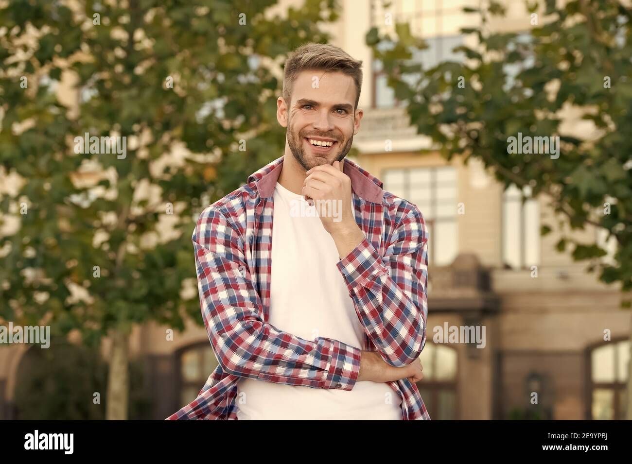 Cool about being scruffy. Unshaven guy smile urban outdoor. Happy man ...