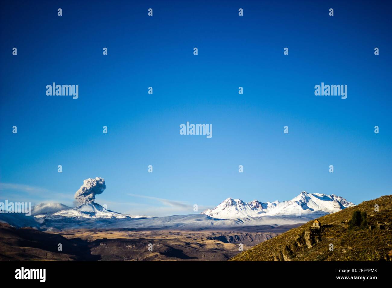 Alpine landscape view of a snowy mountain range during eruption with ...