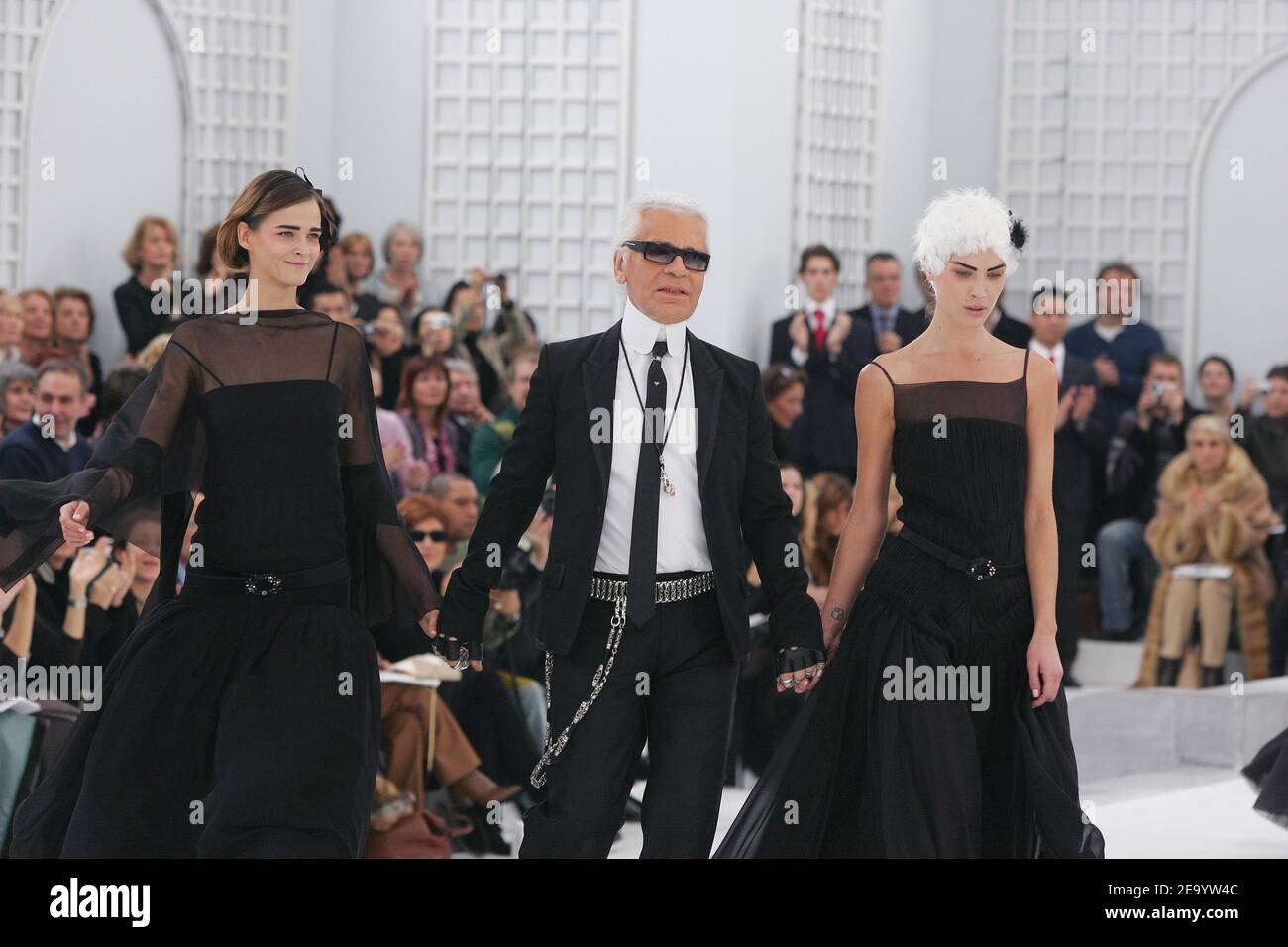 German designer Karl Lagerfeld flanked by models on the runway of the ...