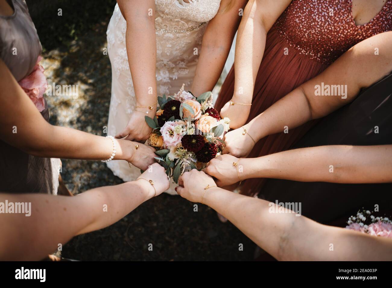 bridesmaids' hands' bracelets with a flower bouquet in the middle Stock ...