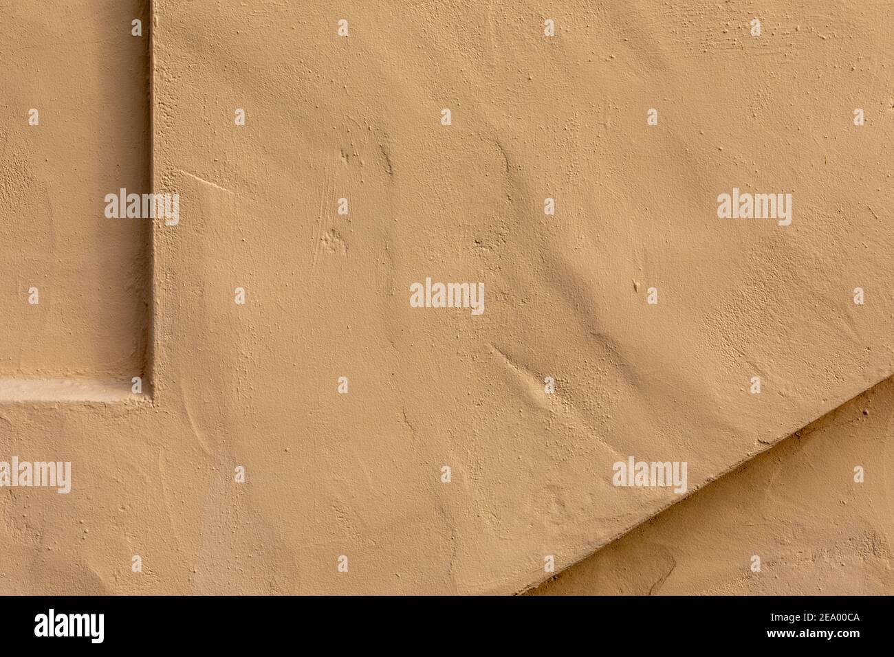 Horizontal close-up image of a beige stucco wall, a long indentation at ...