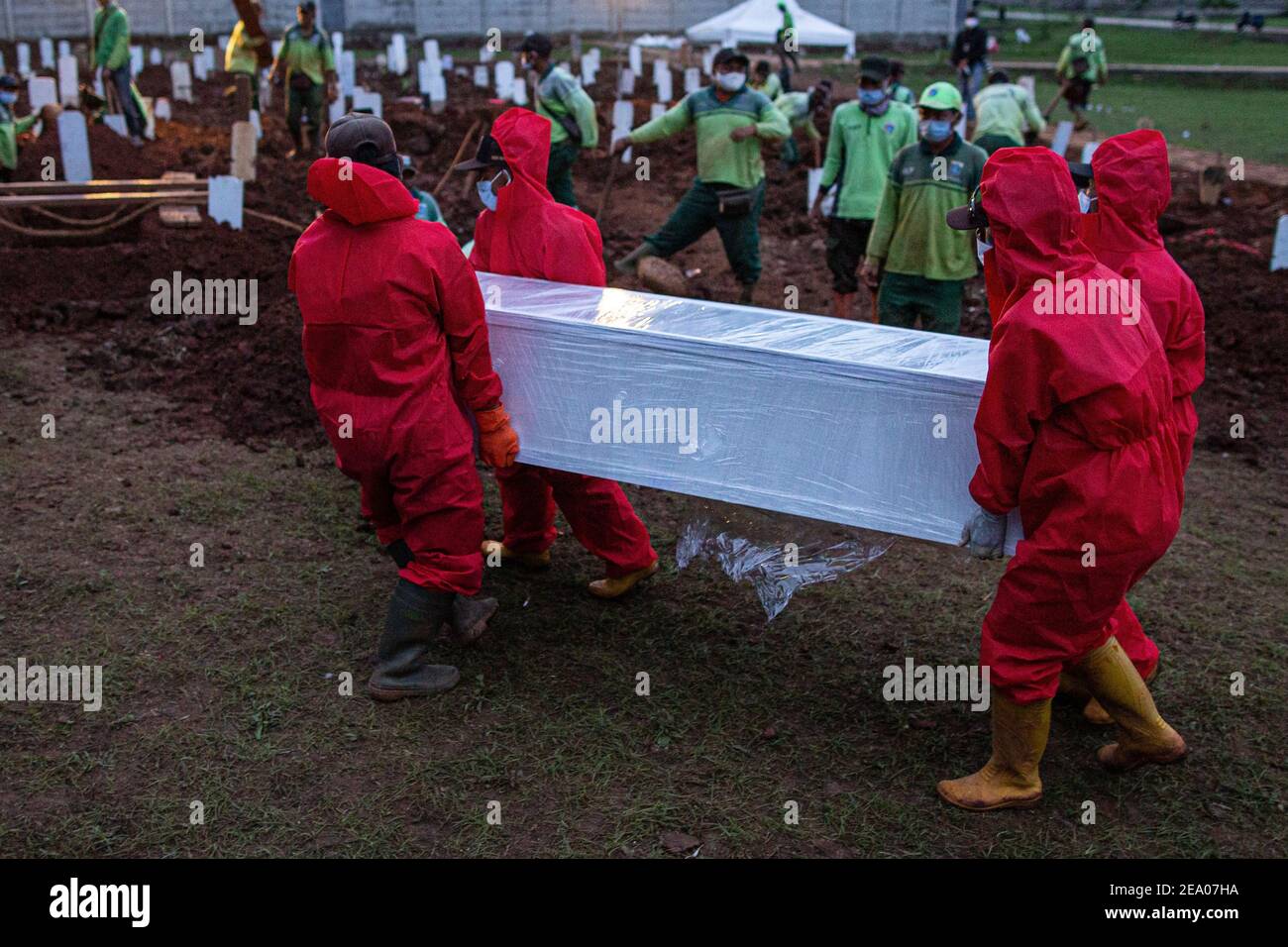 Grave diggers bury a coffin of a Covid-19 coronavirus victim at a ...