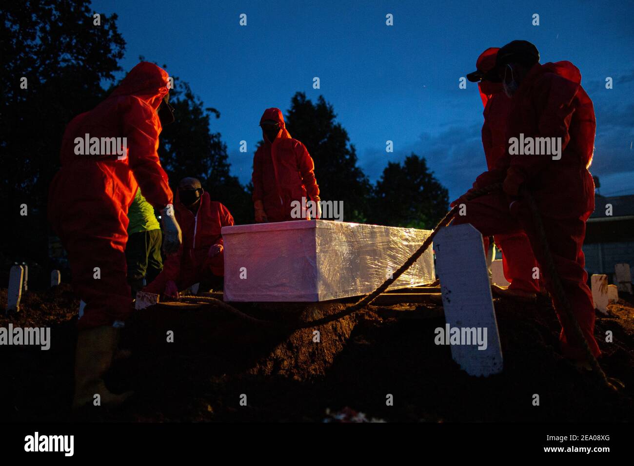 Grave diggers bury a coffin of a Covid-19 coronavirus victim at a ...