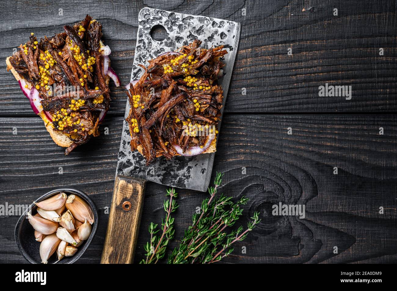 Brisket Sandwich with smoked beef meat on a meat cleaver. Black wooden ...