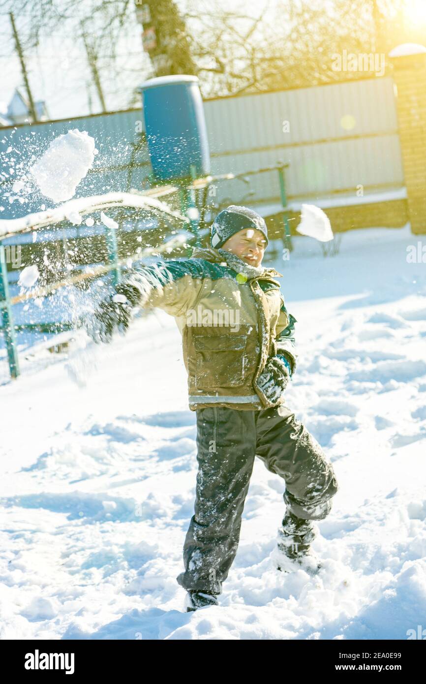 Baby boy walking at snowfall. Child in winter clothes playing with snow ...