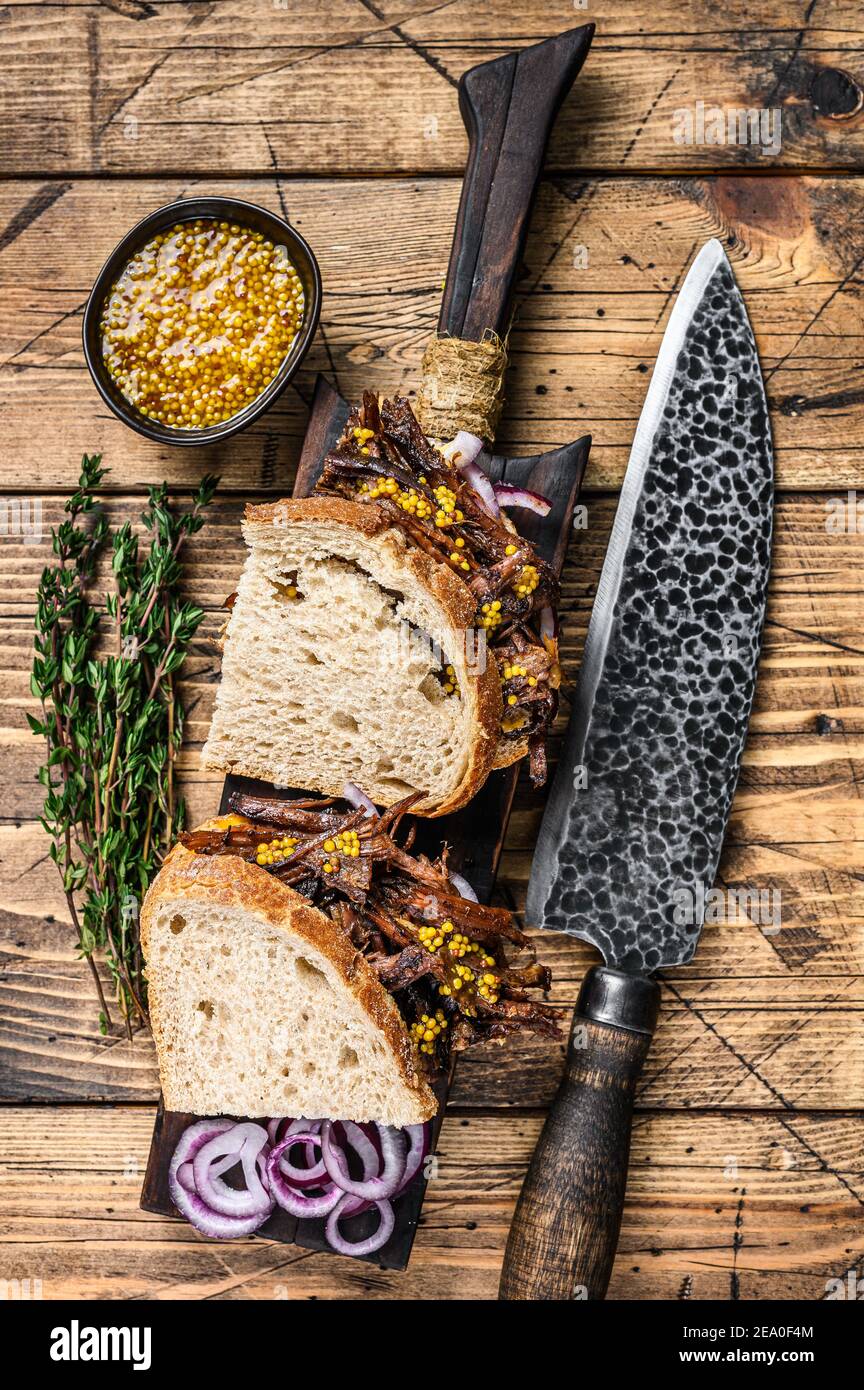 Sandwich with slow smoked beef brisket meat on white bread. wooden ...