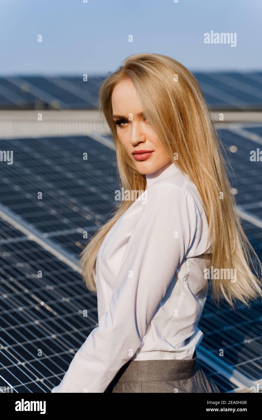 Close-up portrait of blonde model near solar panels. Woman dressed ...