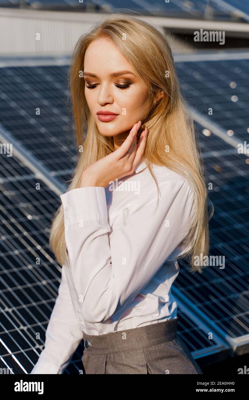Close-up portrait of blonde model near solar panels. Woman dressed ...