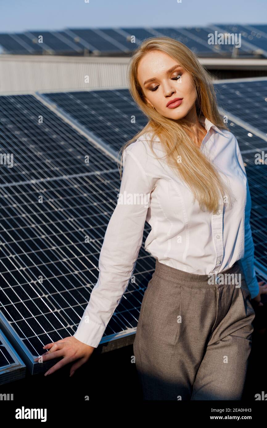 Close-up portrait of blonde model near solar panels. Woman dressed ...
