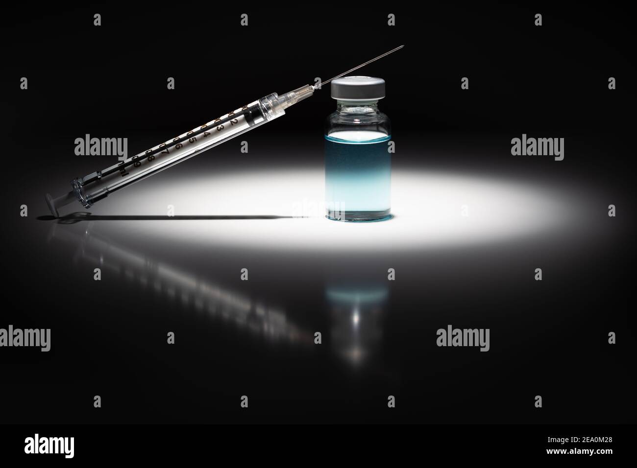 Syringe Needle and Medicine Vial With Light Blue Chemical Spot Lit on ...