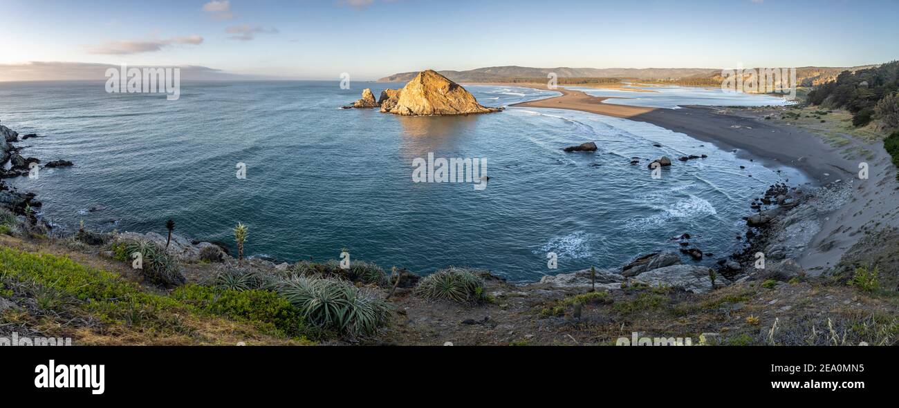 An idyllic and wild beach with a rocky island and a sand tongue ...