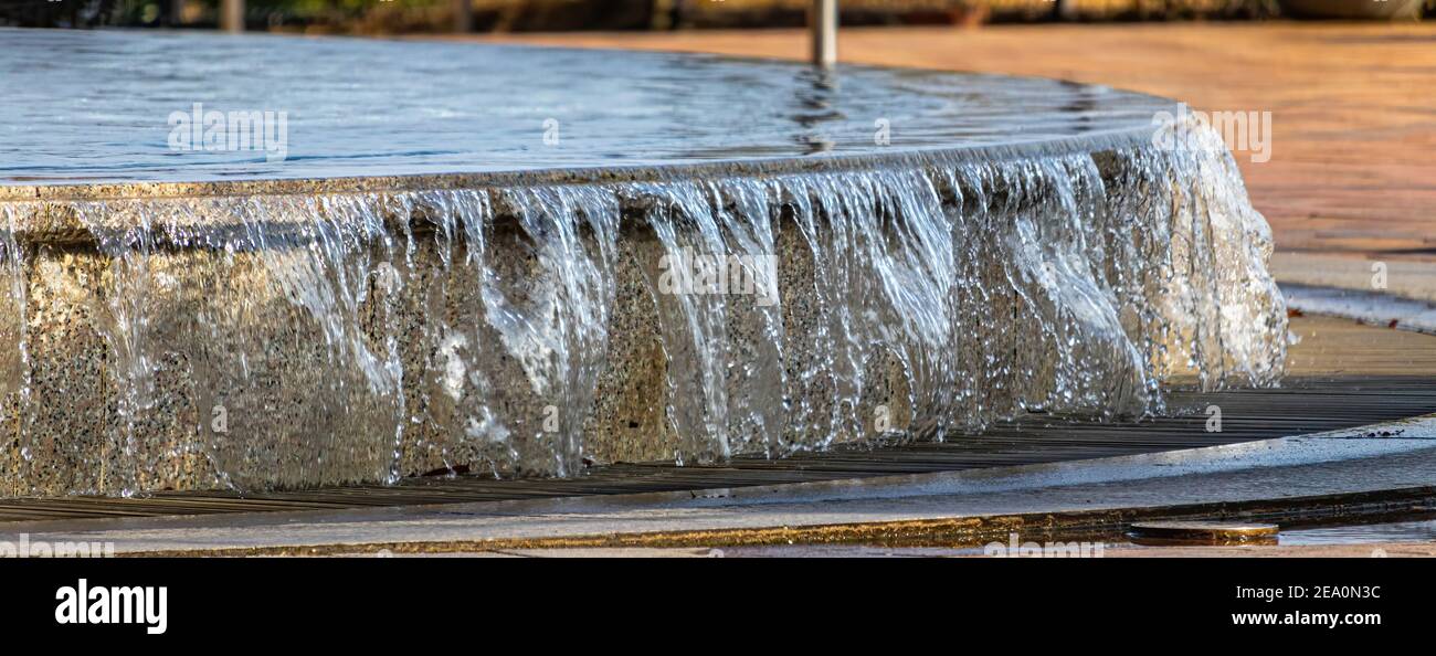 Water flows over the edge of a fountain Stock Photo - Alamy