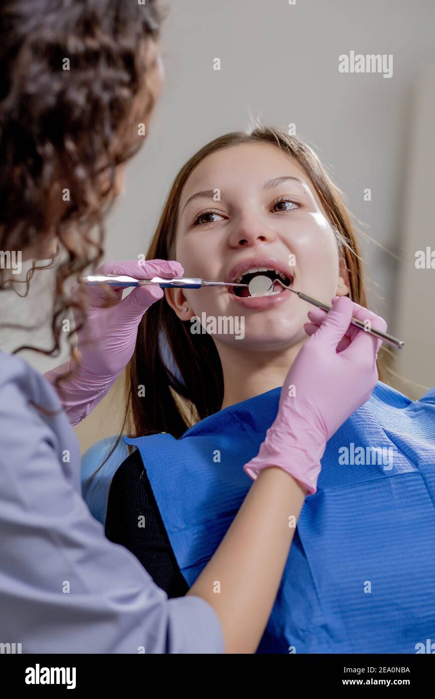 Professional doctor dentist examine and treat spoiled teeth with the ...