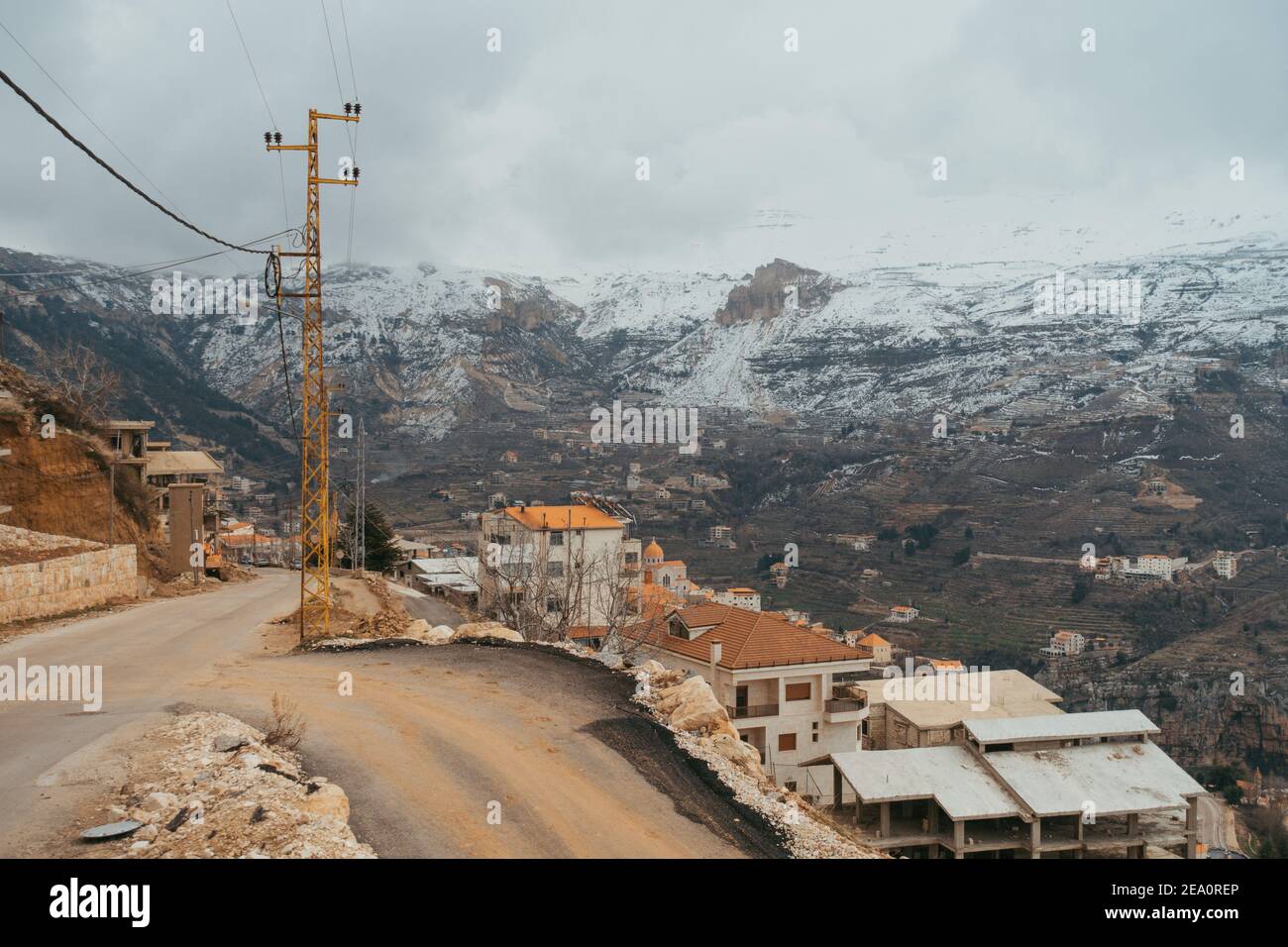 A rural alpine village in Lebanon with a road, houses and power lines ...