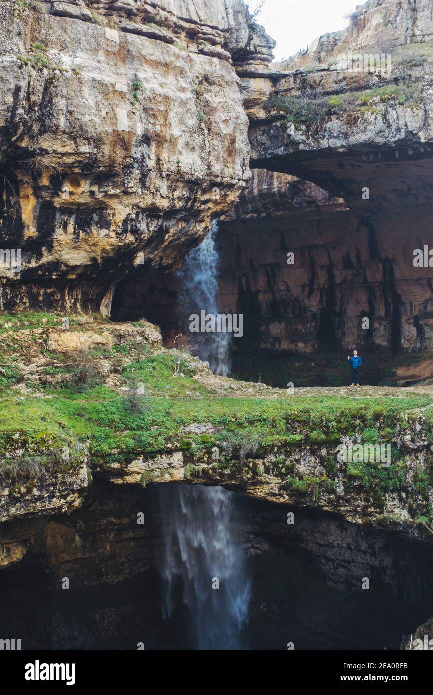 A tourist poses at the Baatara Gorge Waterfall, a 255 metre drop into ...