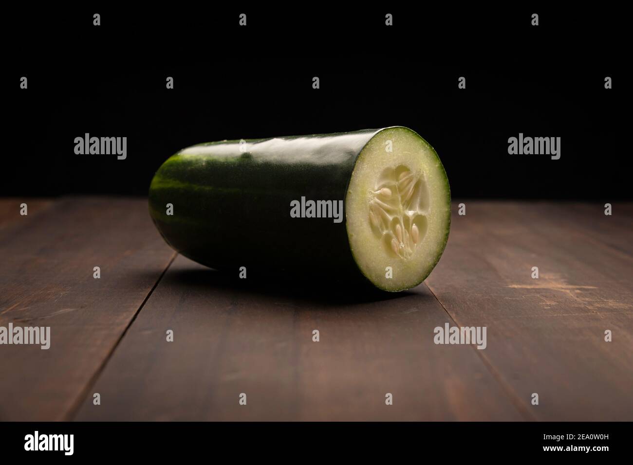 still life image of half cucumber close up on rustic wooden surface and ...