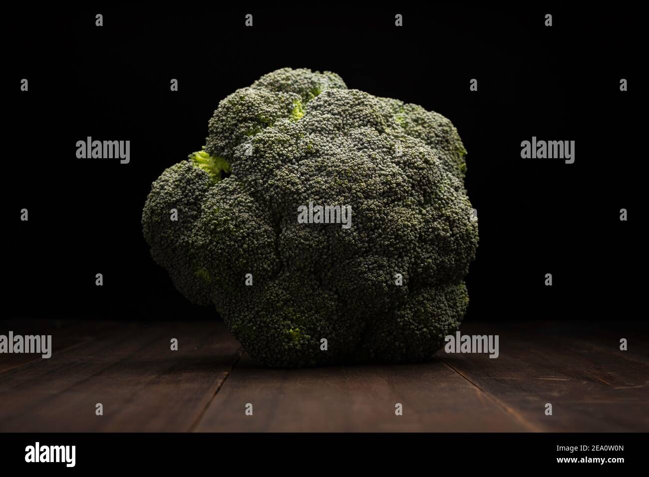 still life image of raw broccoli head crown close up on rustic wooden ...
