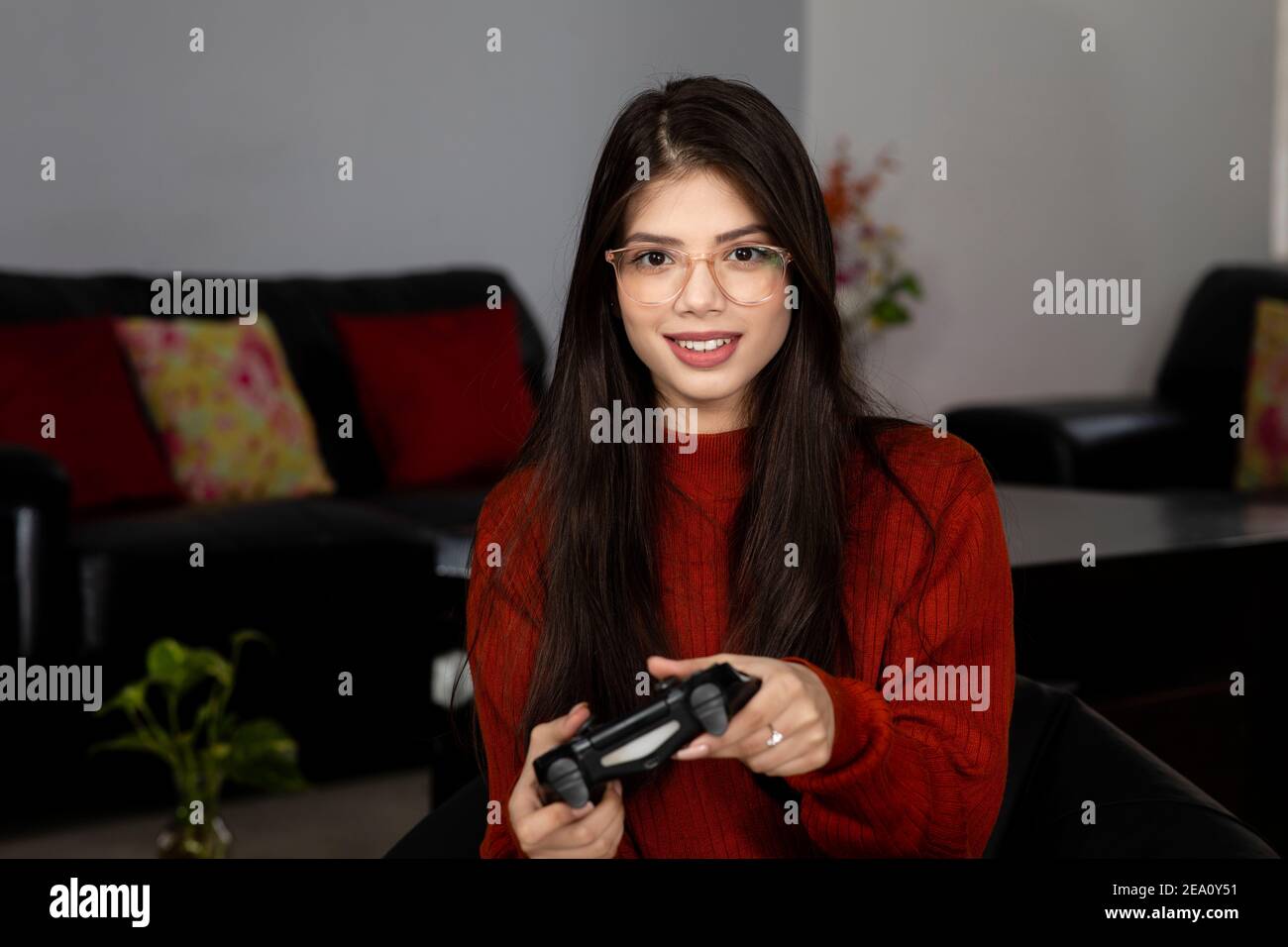 Pretty young woman holding game console in her hands sitting in her ...