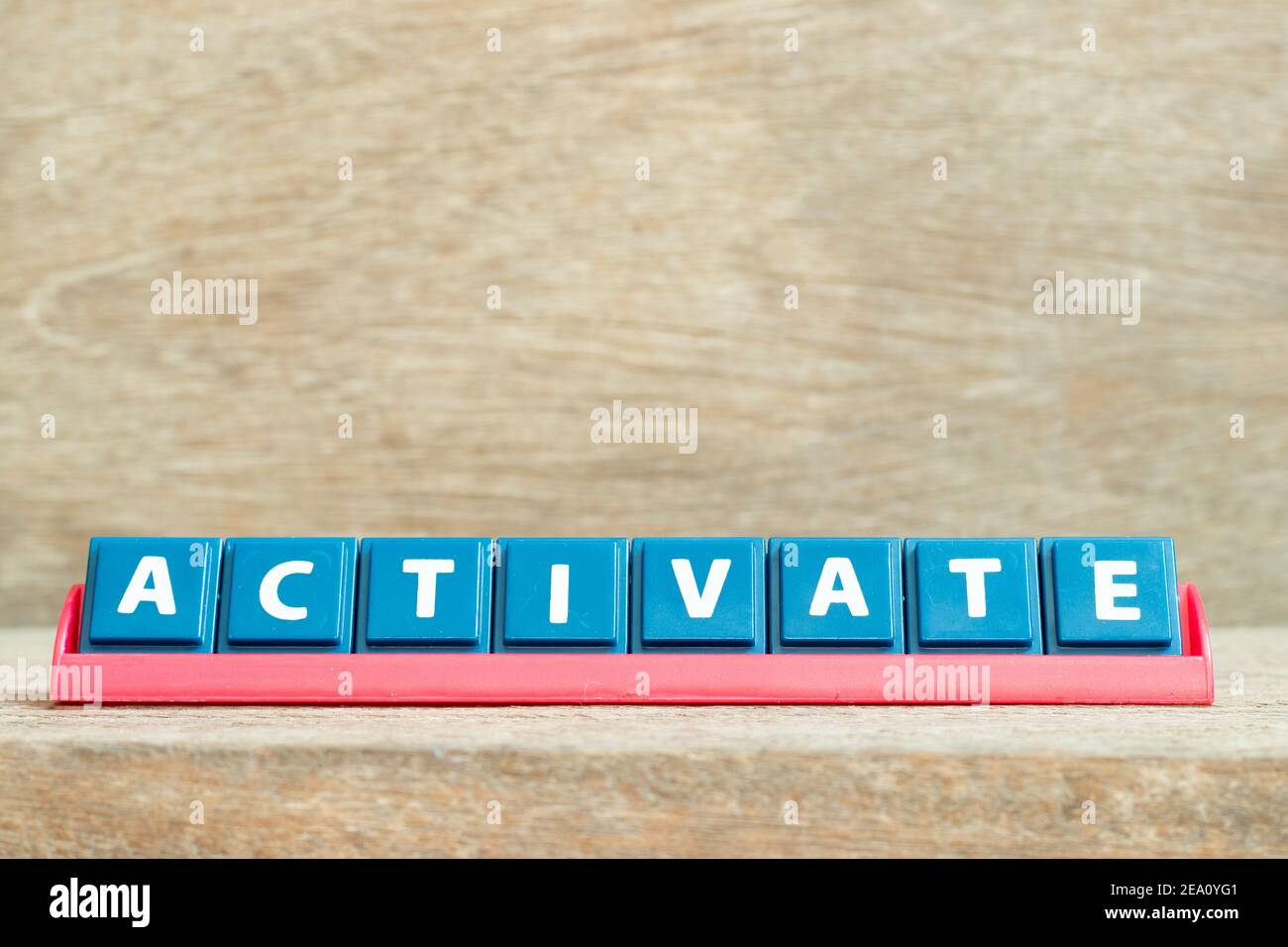Tile alphabet letter with word activate in red color rack on wood ...
