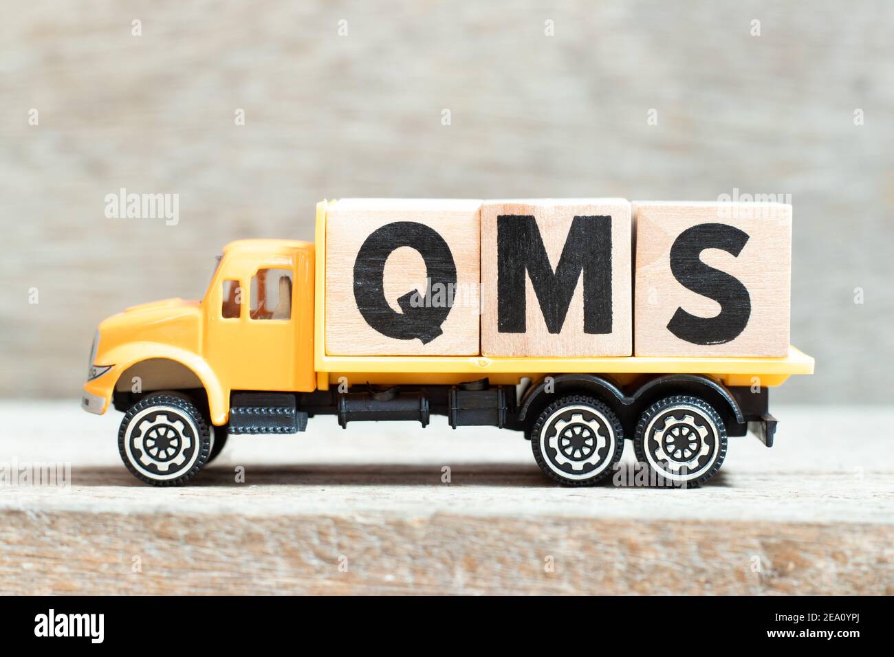 Toy truck hold alphabet letter block in word QMS (abbreviation of ...