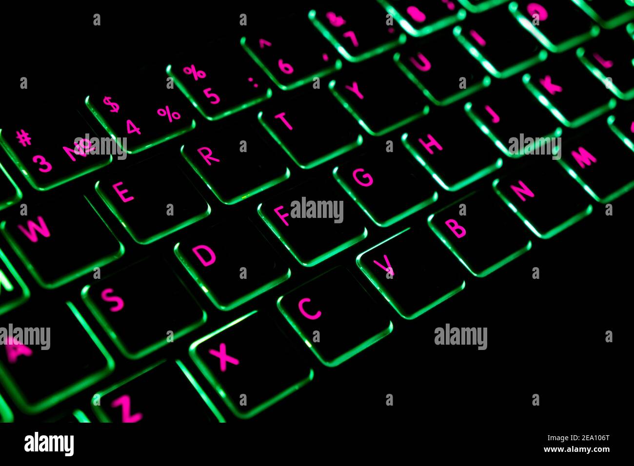 Close up view of a modern laptop computer keyboard key with green ...