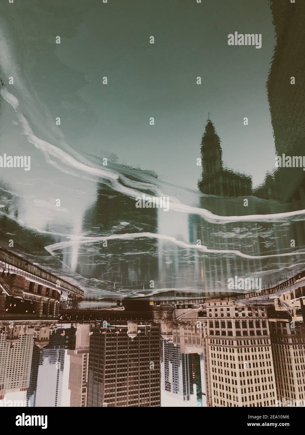 A vertical shot of modern high-rise buildings upside down reflection on ...