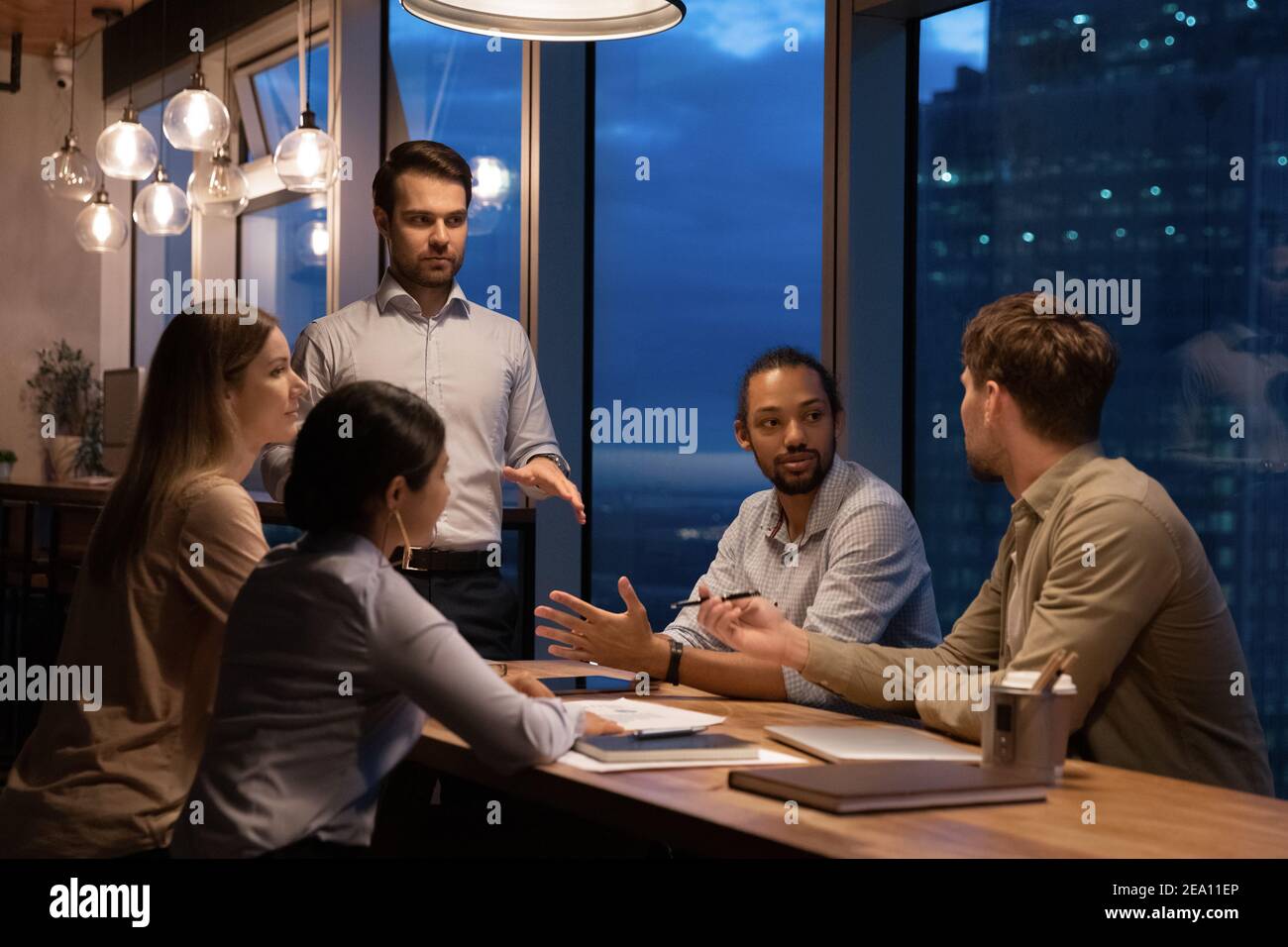 Confident male leader coordinate teamwork of diverse group of managers ...