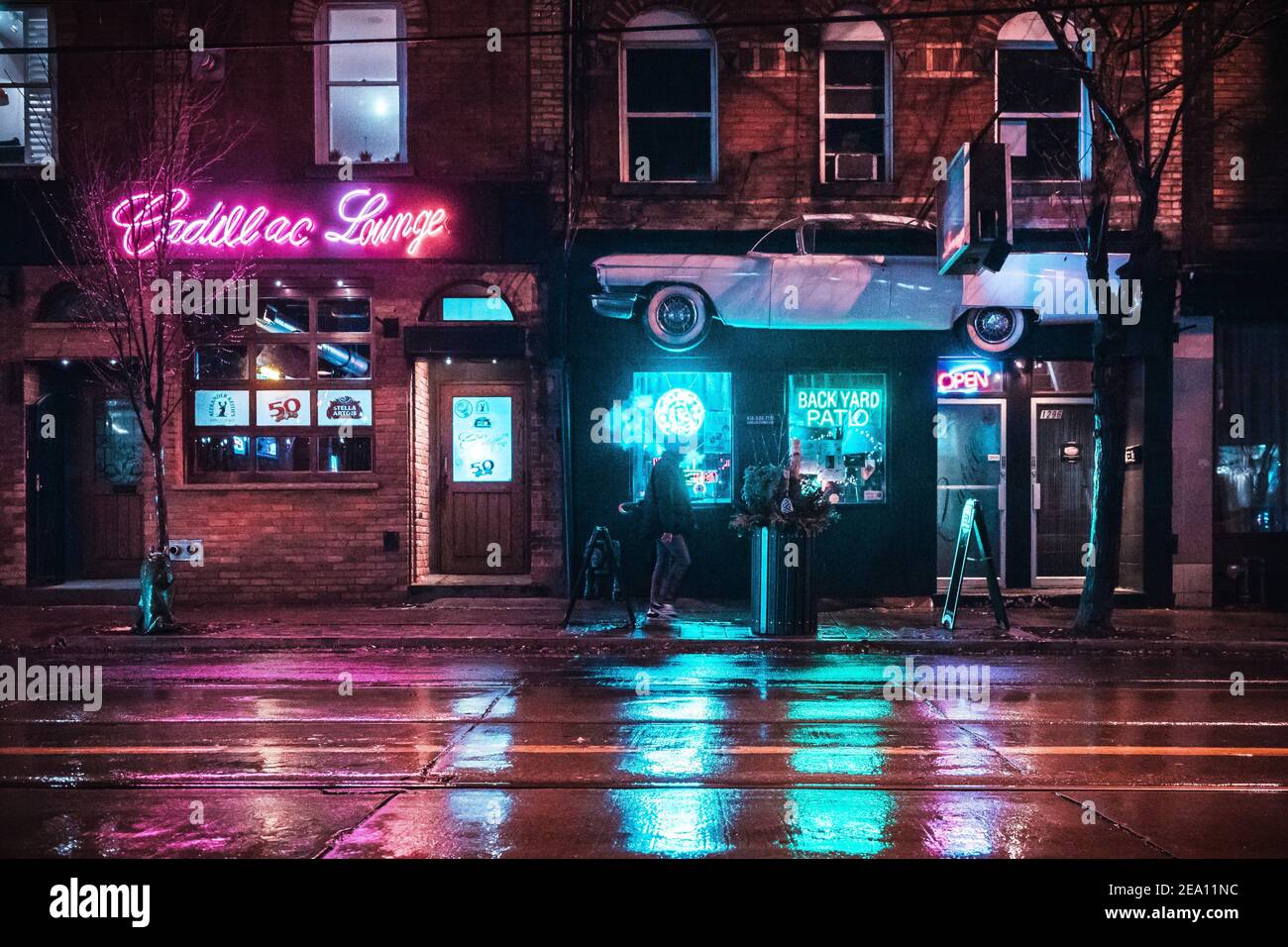 man walking past bar in neon light Stock Photo - Alamy