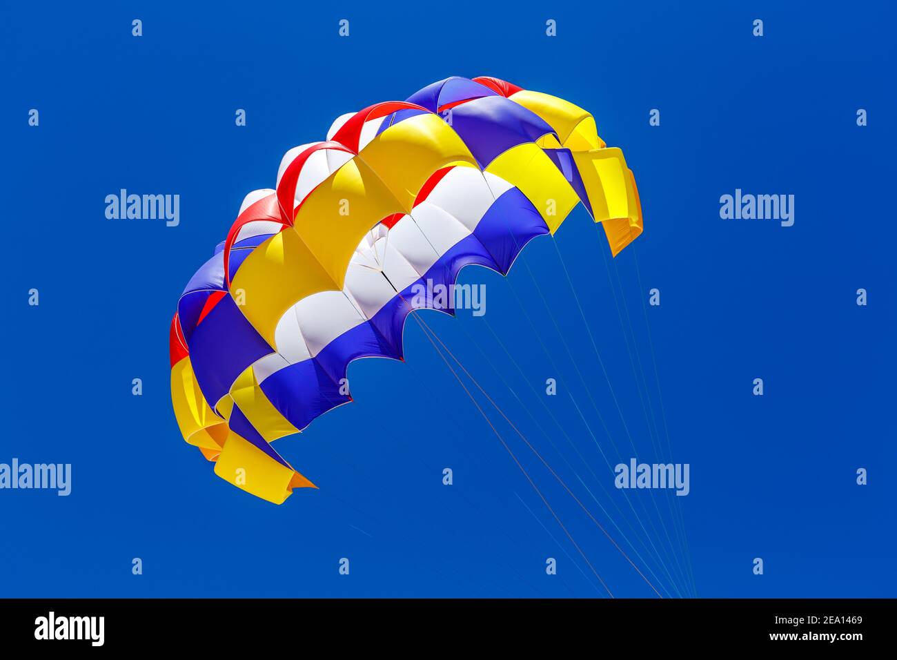 The colorful parachute flying high in the blue sky Stock Photo - Alamy