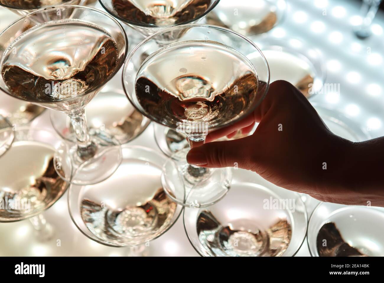 Hand with glass of sparkling wine, lit from below Stock Photo - Alamy