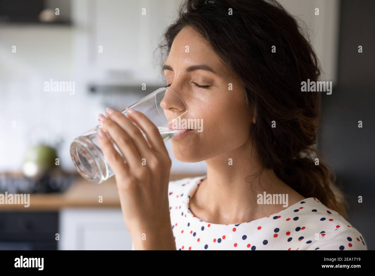 Thirsty young woman drink water from glass Stock Photo - Alamy
