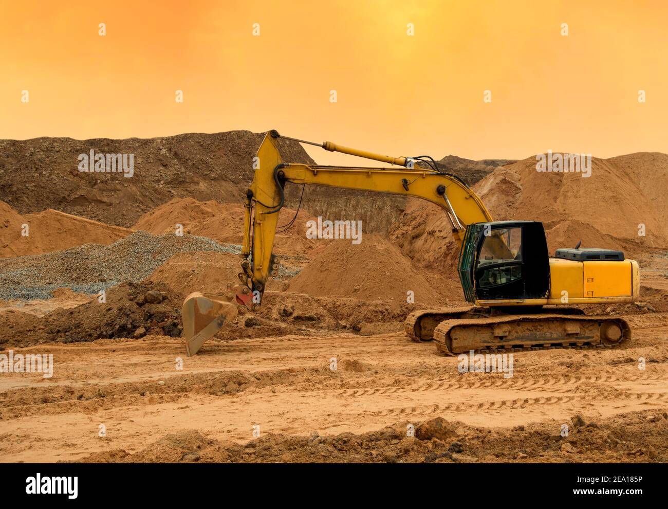 Excavator working on earthmoving at open pit mining on amazing sunset ...