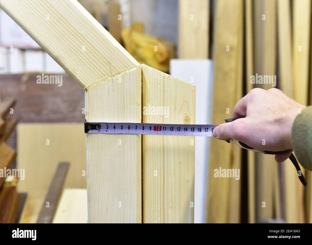Measuring the thickness of a wooden beam using a construction tape ...