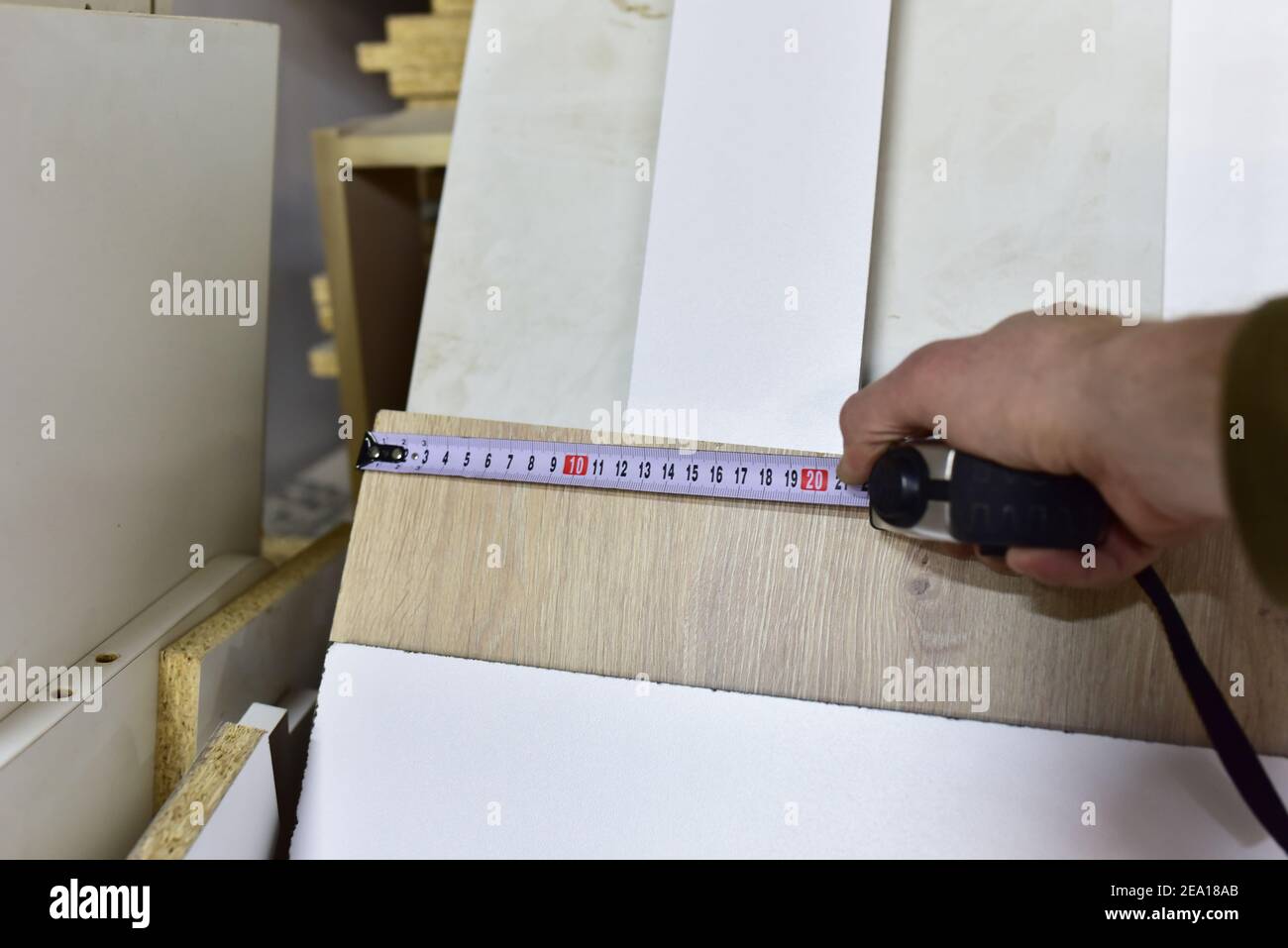 Measuring the width wooden Panel using a construction tape. Medium ...