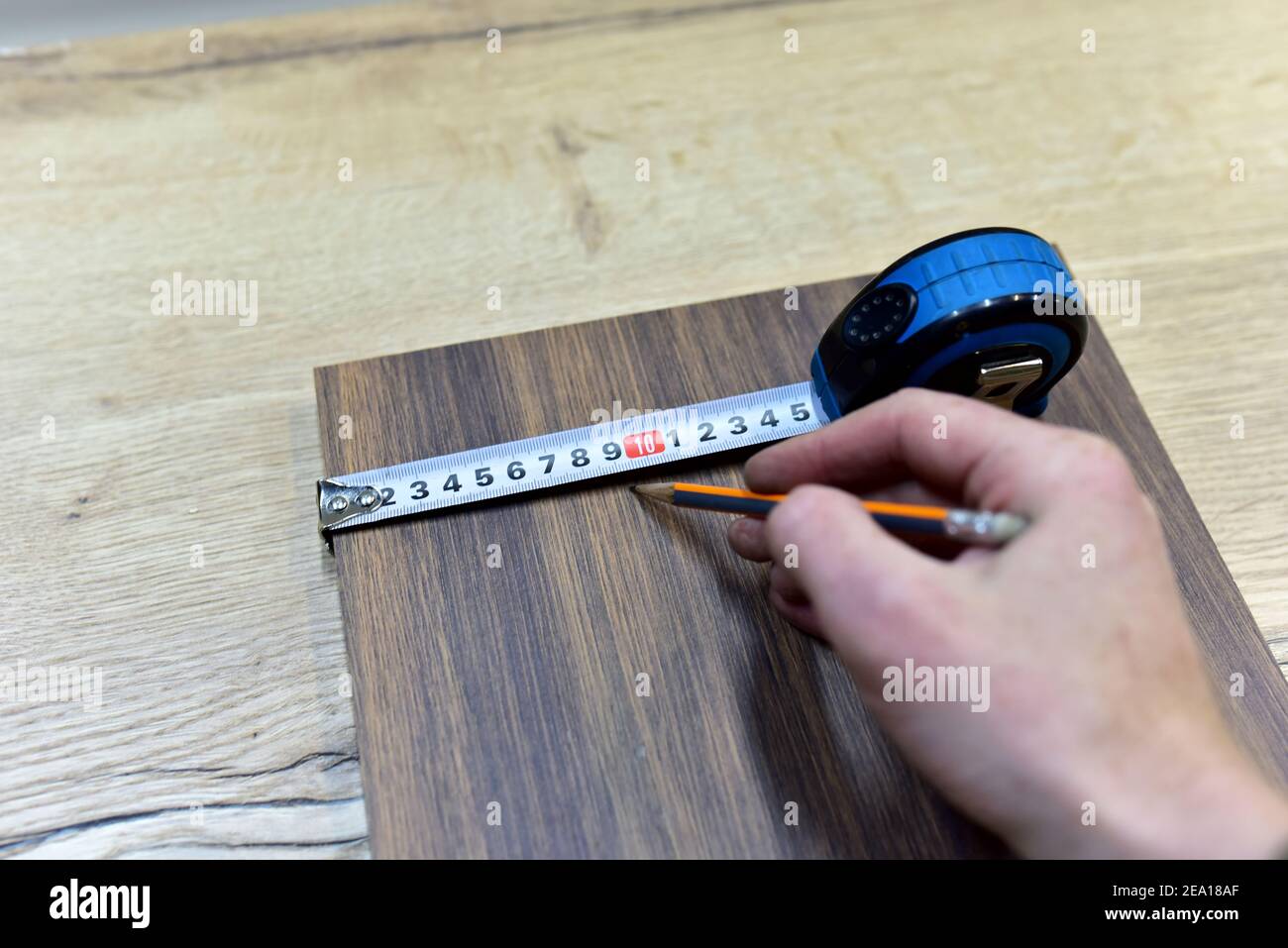 Measuring the width wooden Panel using a construction tape ...