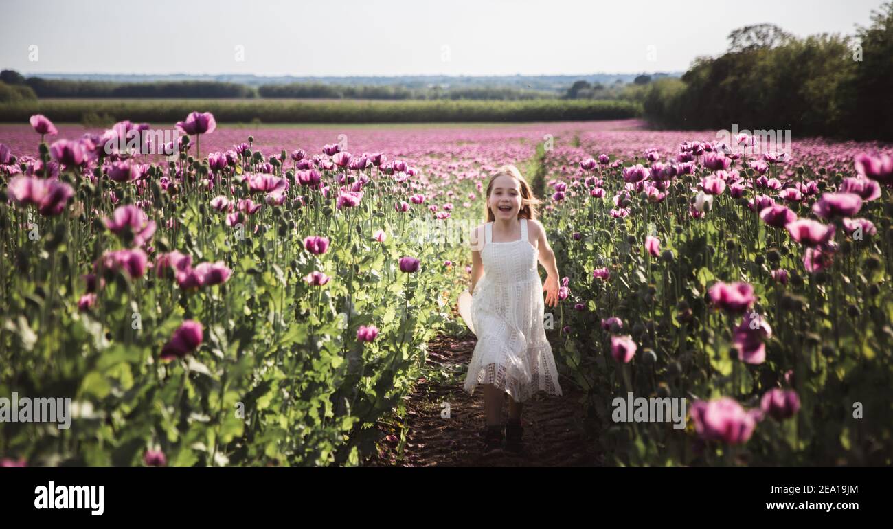 Adorable little girl with long hair in white dress lonely walking in ...