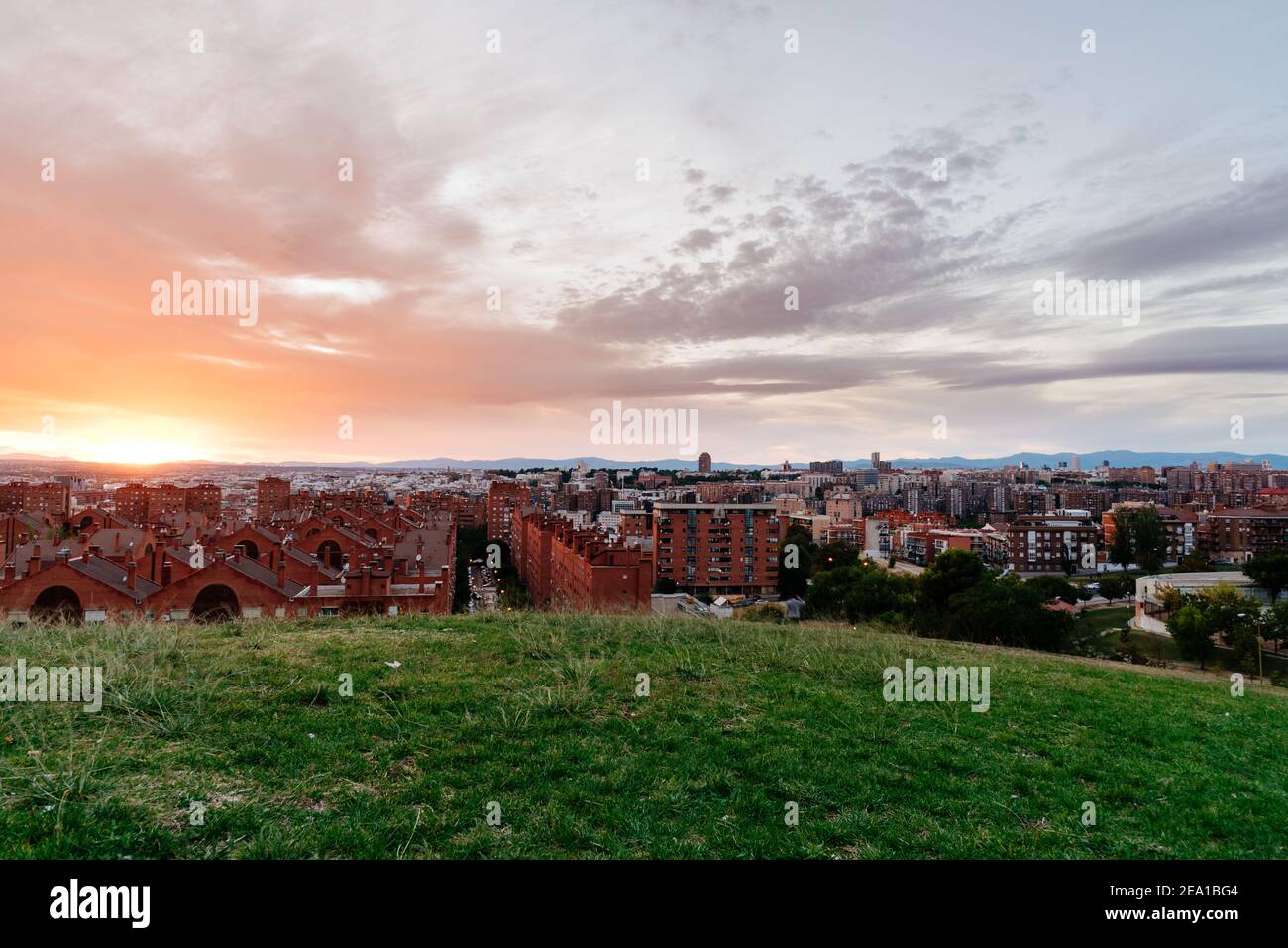 Madrid cityscape at dusk from a residential district and mountain range ...