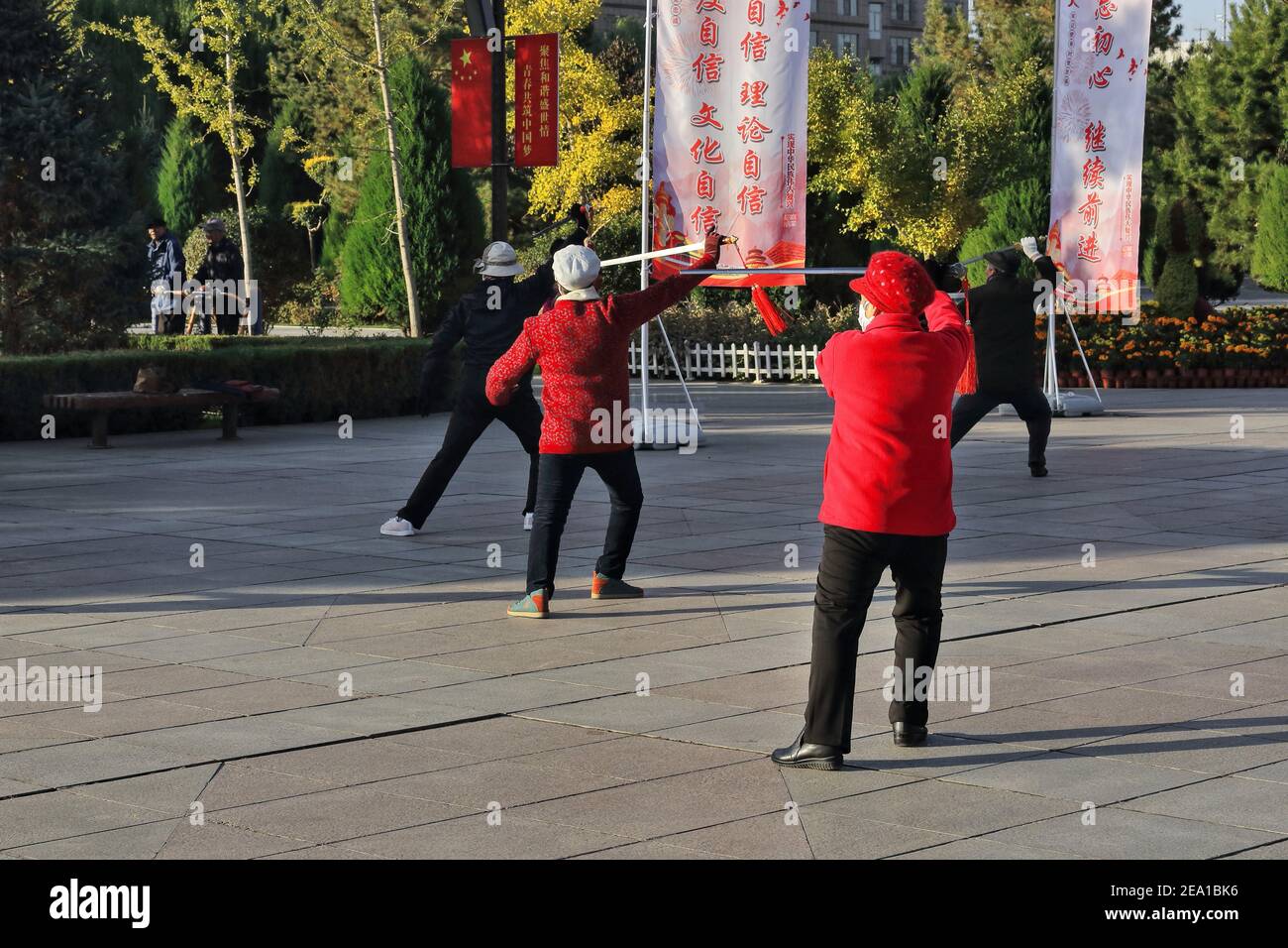 Group of taijijian-sword tai chi practitioners in the morning sun ...