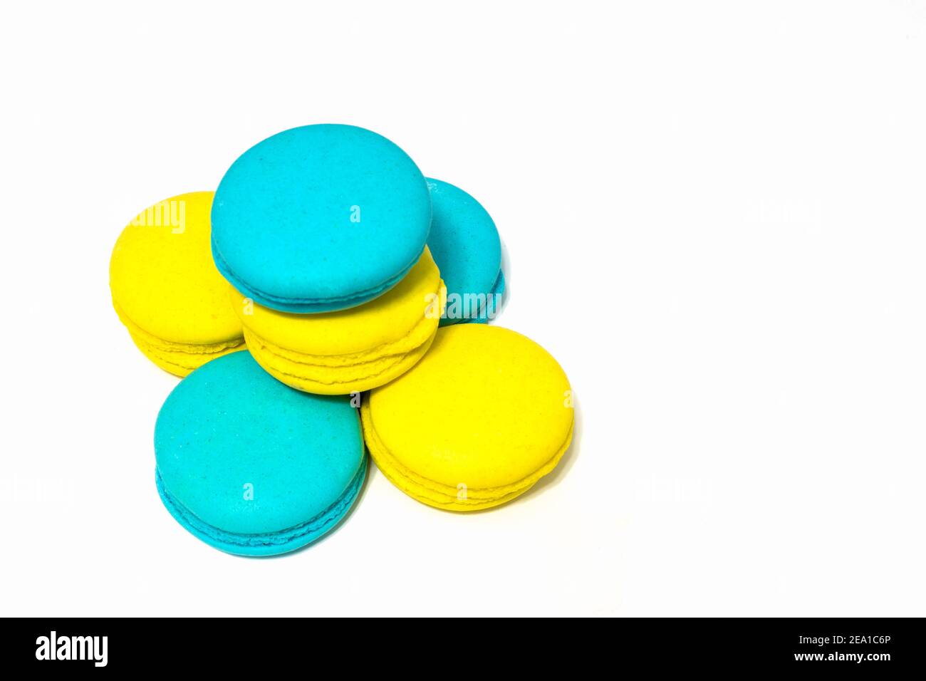yellow and blue macaroni cookies stacked in a stack on an isolated ...
